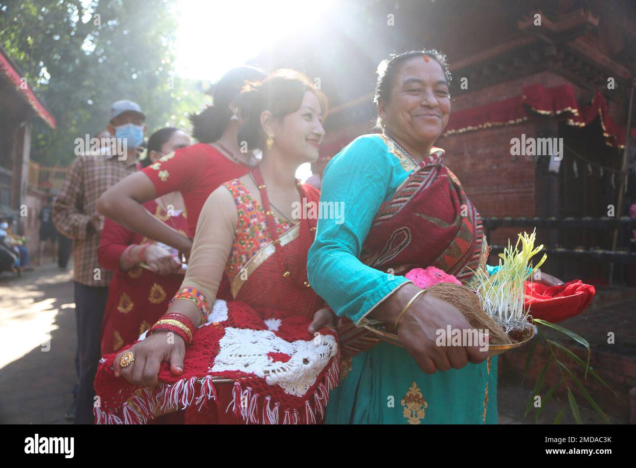 Hindu devotees stand in a queue to offer prayers at a temple on the ...