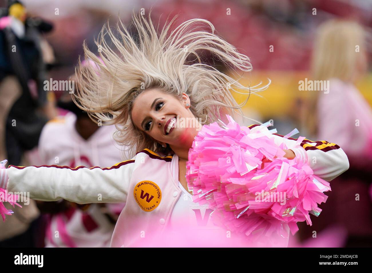 A Washington Football Team cheerleader performs with a pink pompom in ...