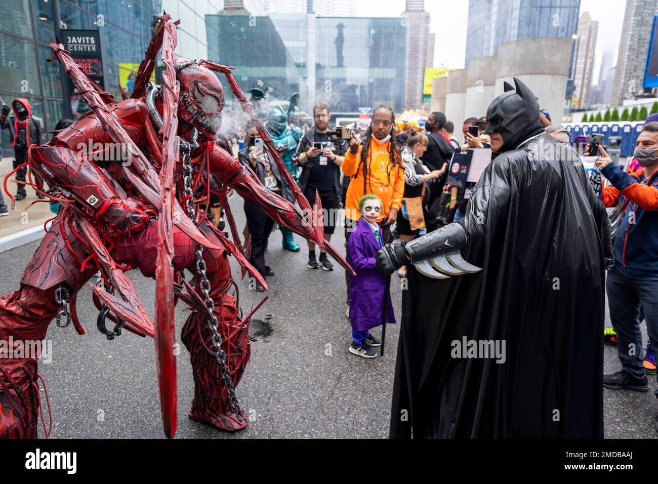 Attendees dressed as Carnage and Batman pose during New York Comic Con ...