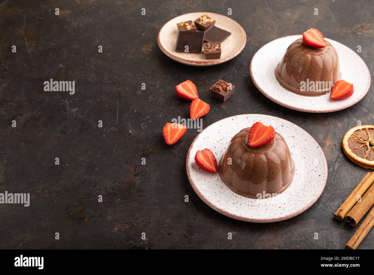 Chocolate jelly with strawberry on black concrete background. side view ...