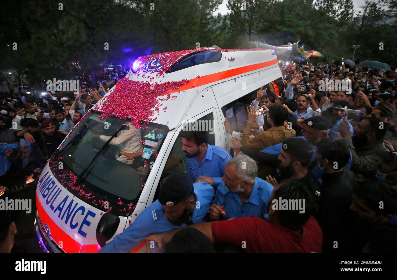 Police officers clear the way for an ambulance carrying the casket of ...