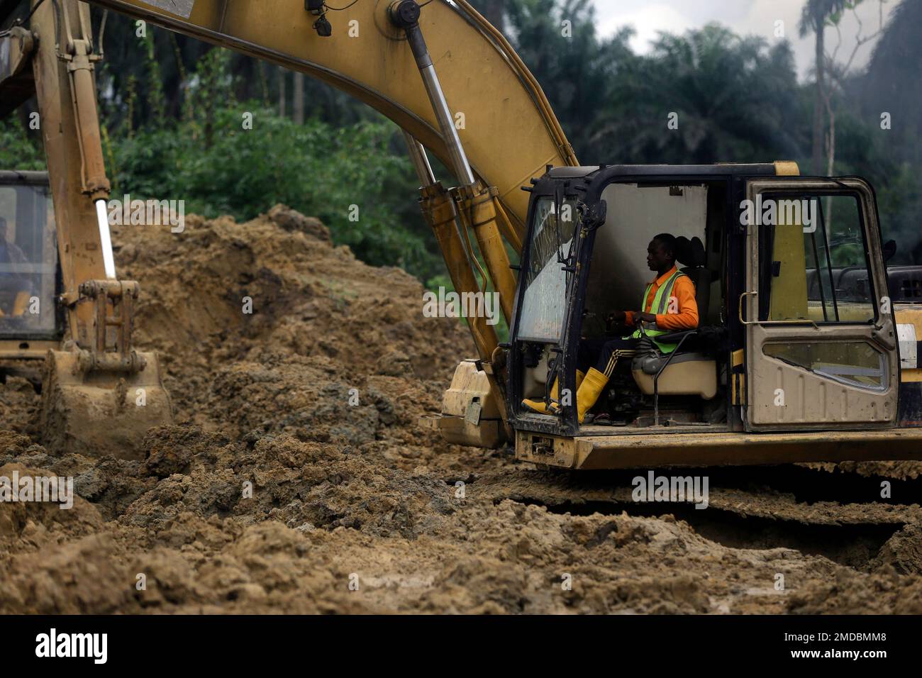 Workers use caterpillars to excavate contaminated soil caused by oil ...
