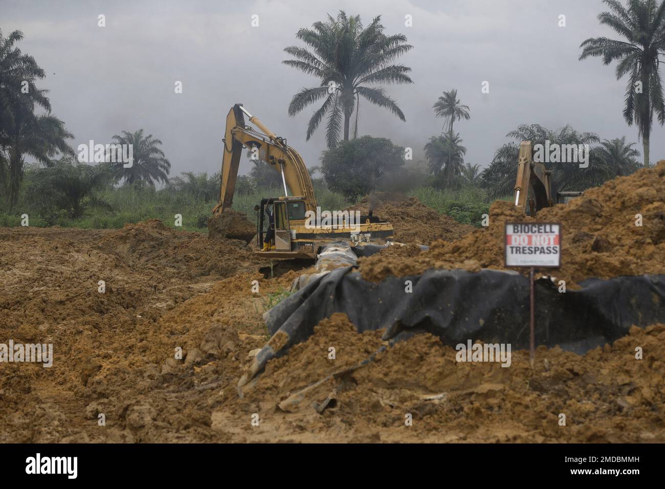 Workers use caterpillars to excavate contaminated soil caused by oil ...
