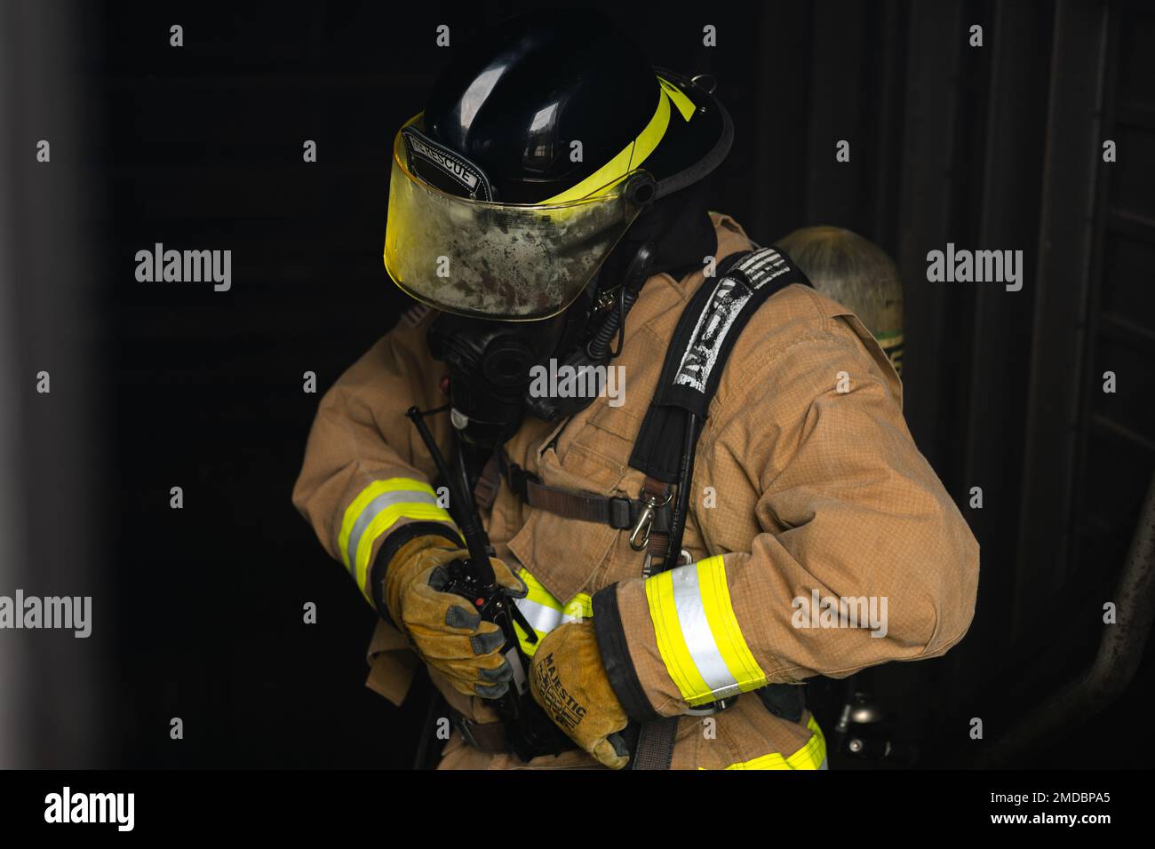 A 375th Civil Engineer Squadron firefighter attaches a radio to his ...