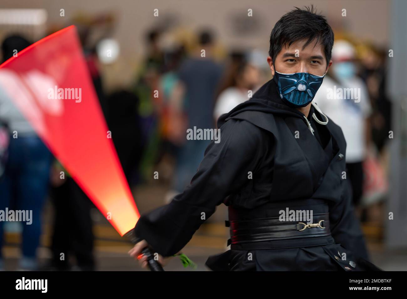 An attendee dressed as a Jedi shows off his lightsaber skills during ...