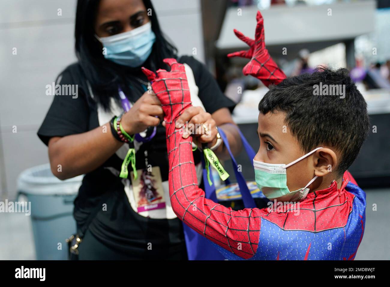 Bianca Gonzalez, left, helps her son Mason Brito, 6, with his Spider ...