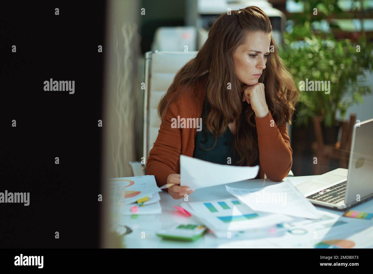 pensive modern middle aged small business owner woman with laptop ...