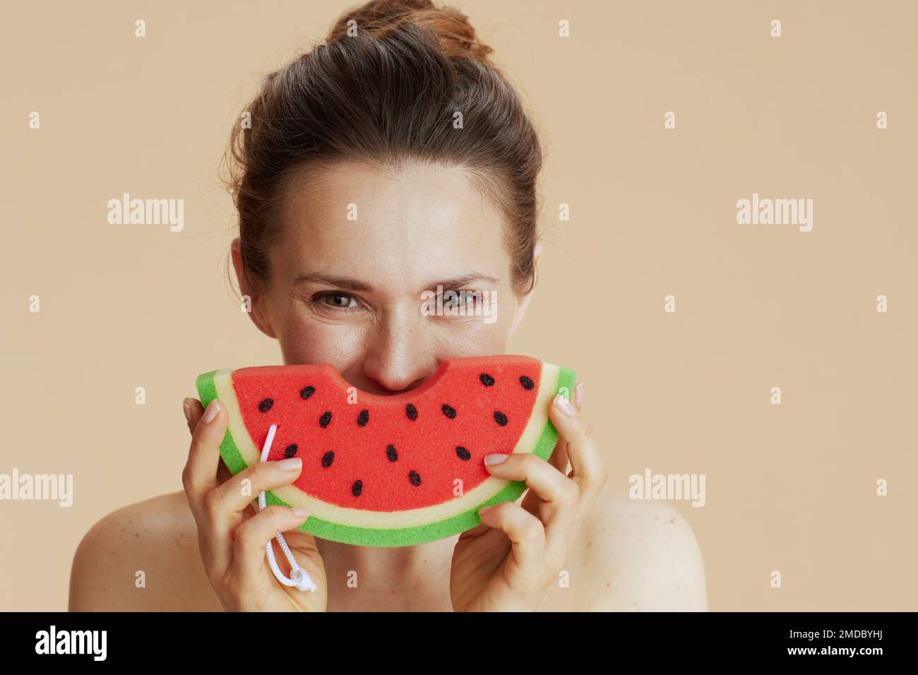 happy modern woman with watermelon shower sponge on beige background ...