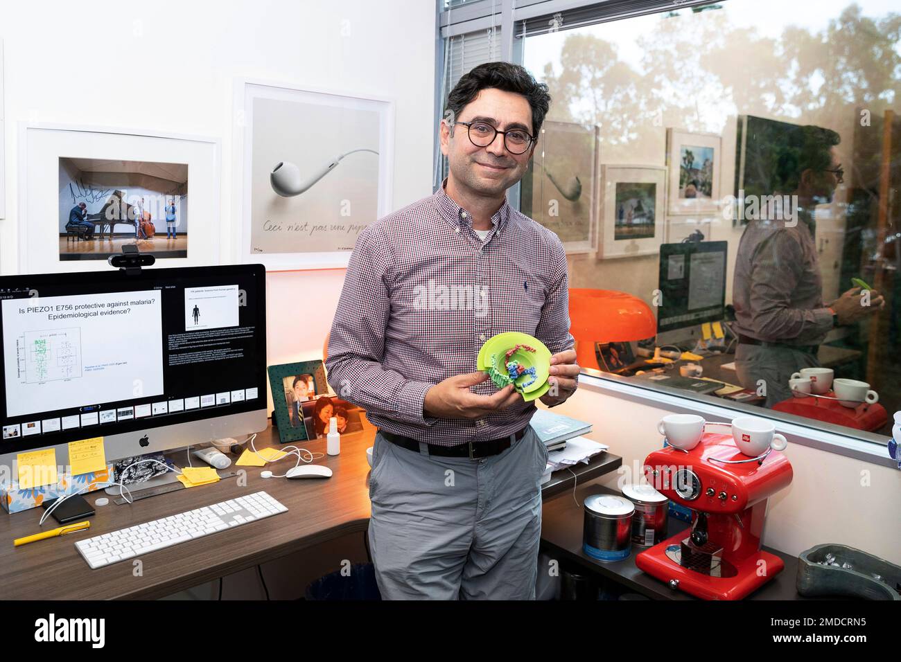 Ardem Patapoutian poses for a portrait in his office while holding a ...