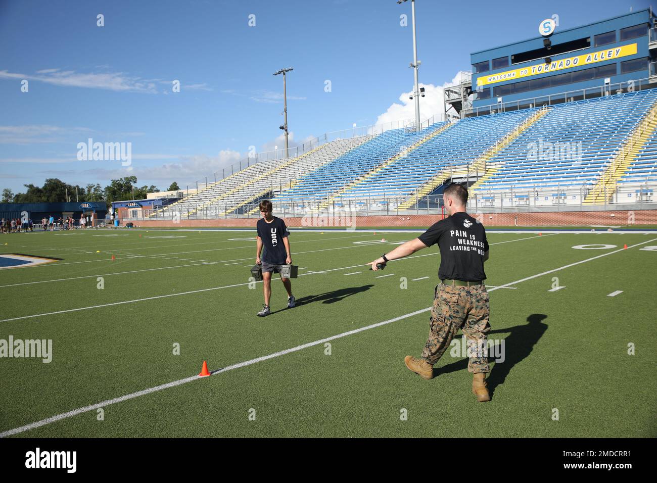 U.S. Marine Corps Sgt. Michael Moreland directs an athlete through a ...