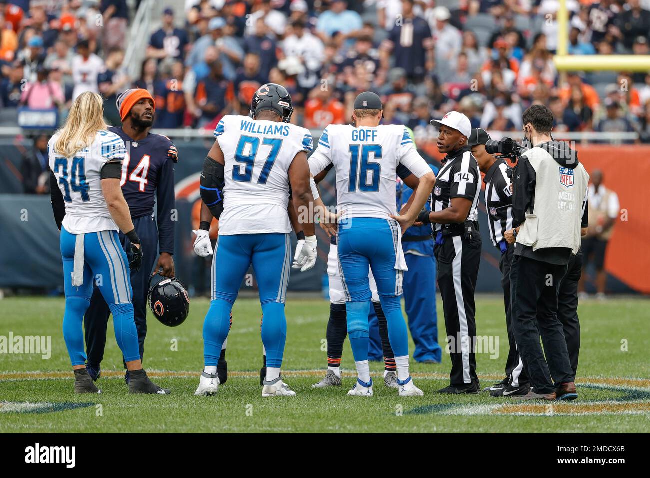 Referee Shawn Smith (14) talks with Detroit Lions quarterback Jared ...