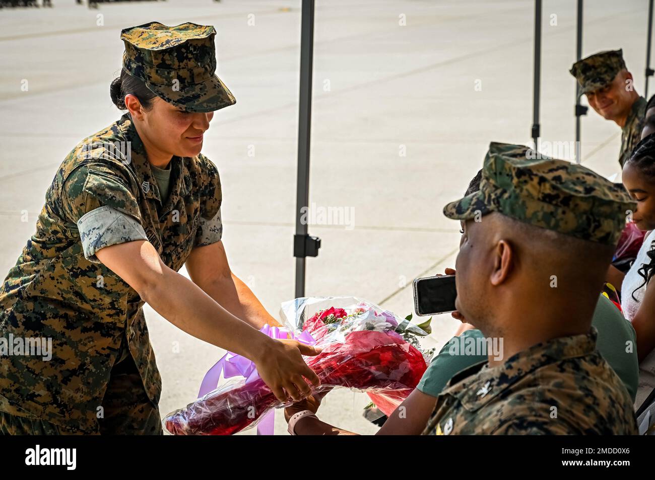 A U.S. Marine assigned to Marine Aircraft Group 49 gives flowers to the ...