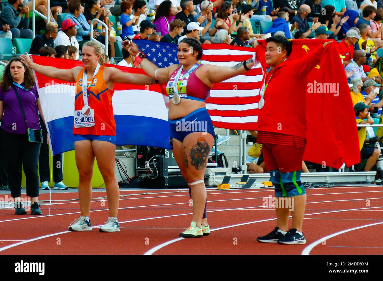 Chase Ealey (center) proudly displays the American flag and her gold ...