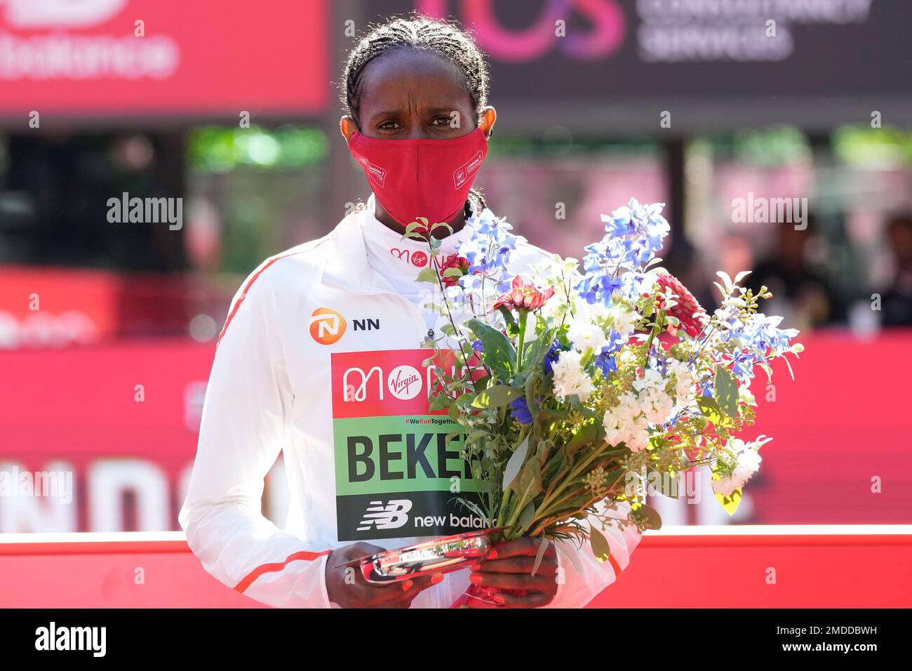 Ethiopia's Ashete Bekere holds flowers and her trophy after taking ...