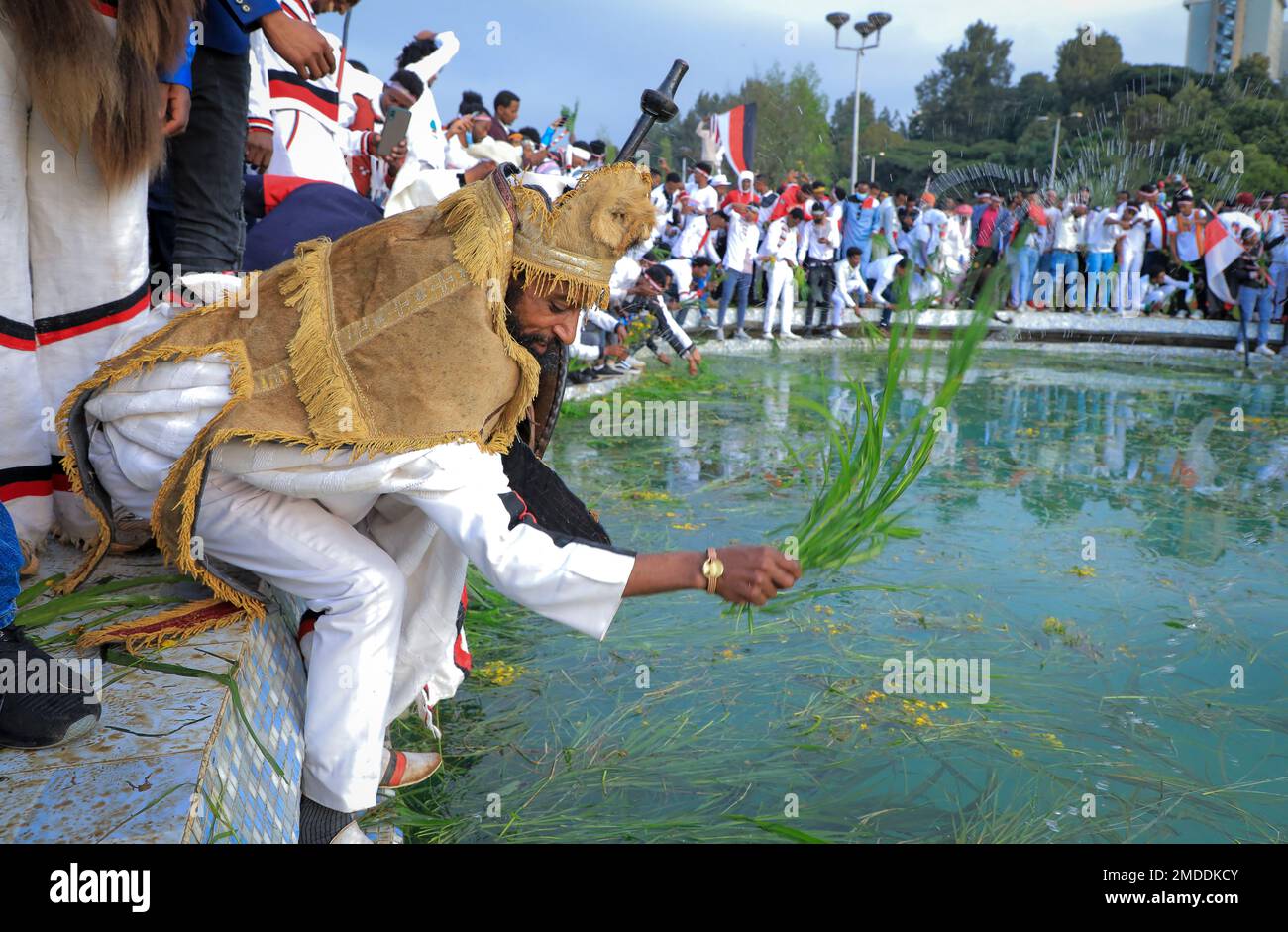 Oromos throw grass and flowers into a pool of water as they celebrate ...