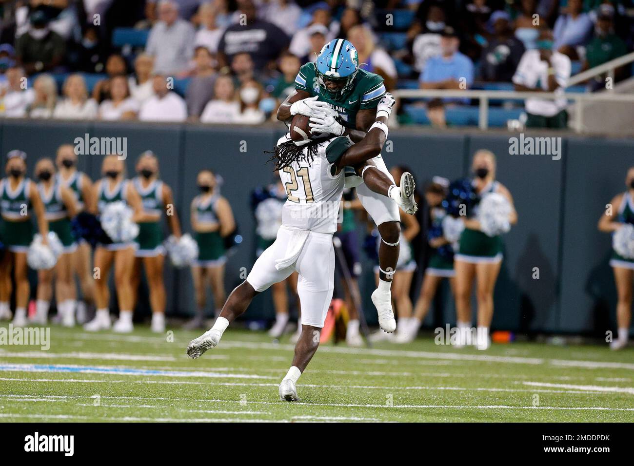 Tulane running back Ygenio Bookers (5) reaches over UAB safety Will ...
