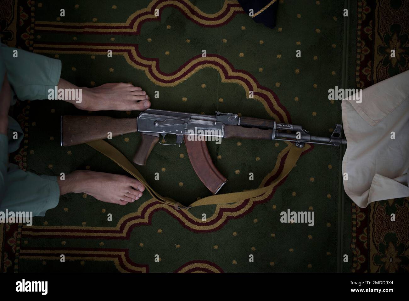 A Taliban fighter lays his AK-47 rifle down during Friday prayers at a ...