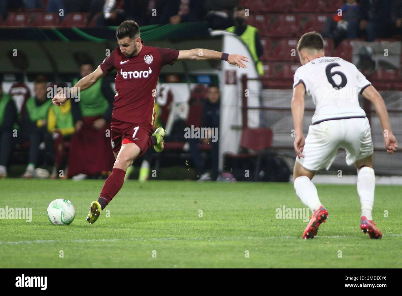 CFR's Constantin Paun kicks the ball next to Randers' Lasse Berg ...