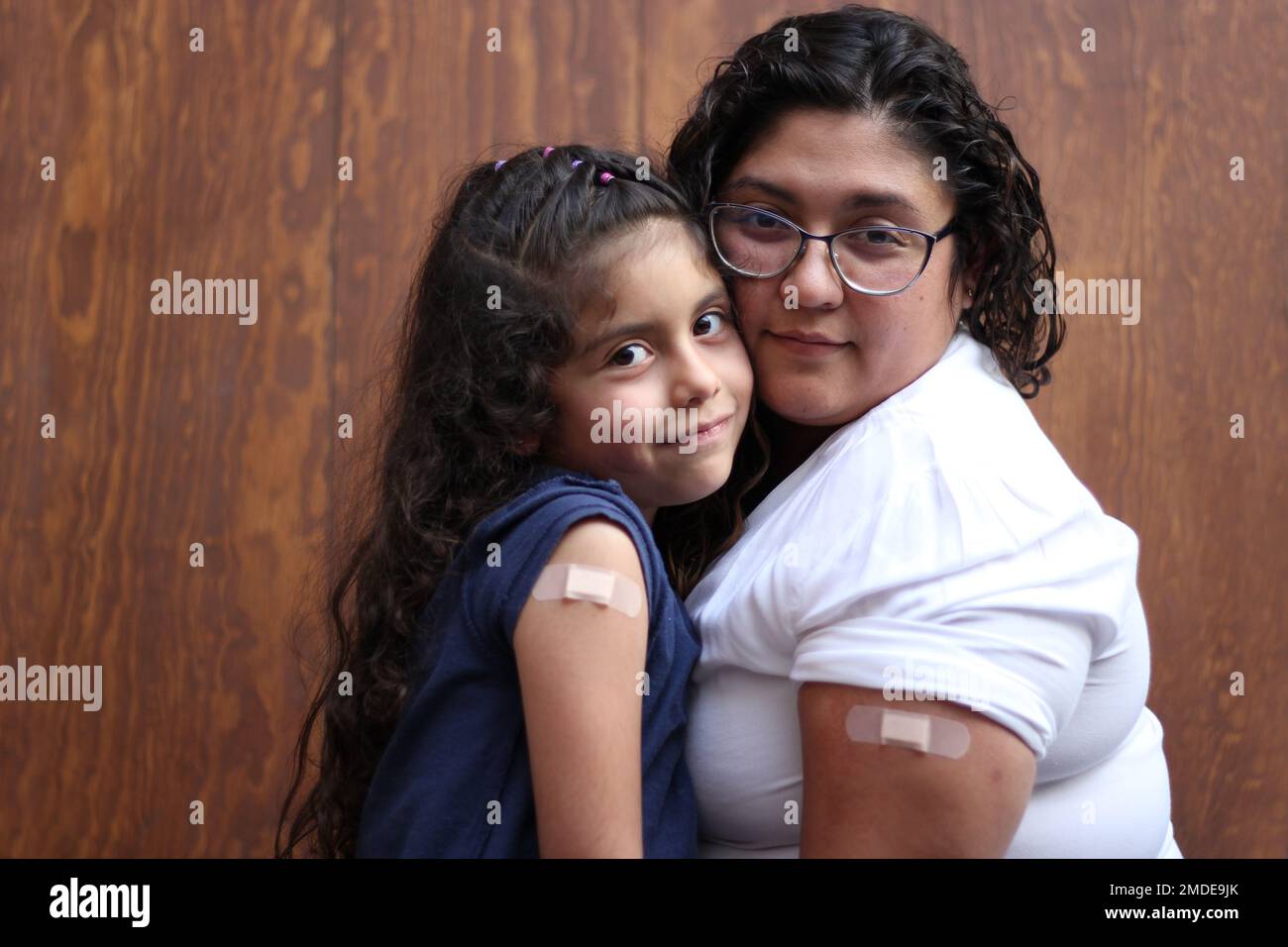 Happy And Hugging Latin Mom And Daughter Show Their Recently Vaccinated