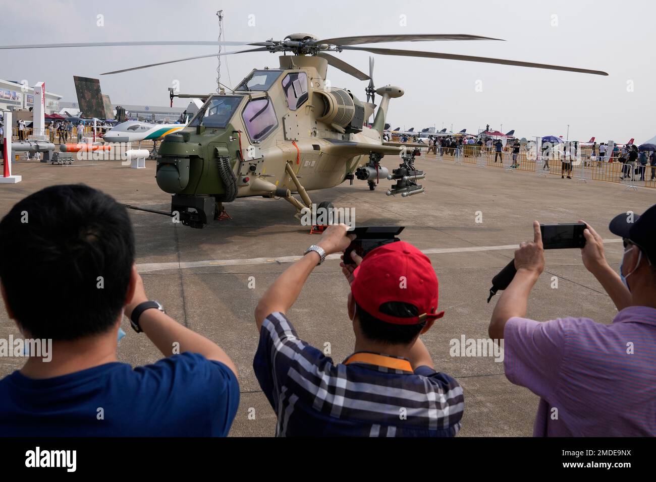 Visitors take photos of a Chinese military attack helicopter displayed ...