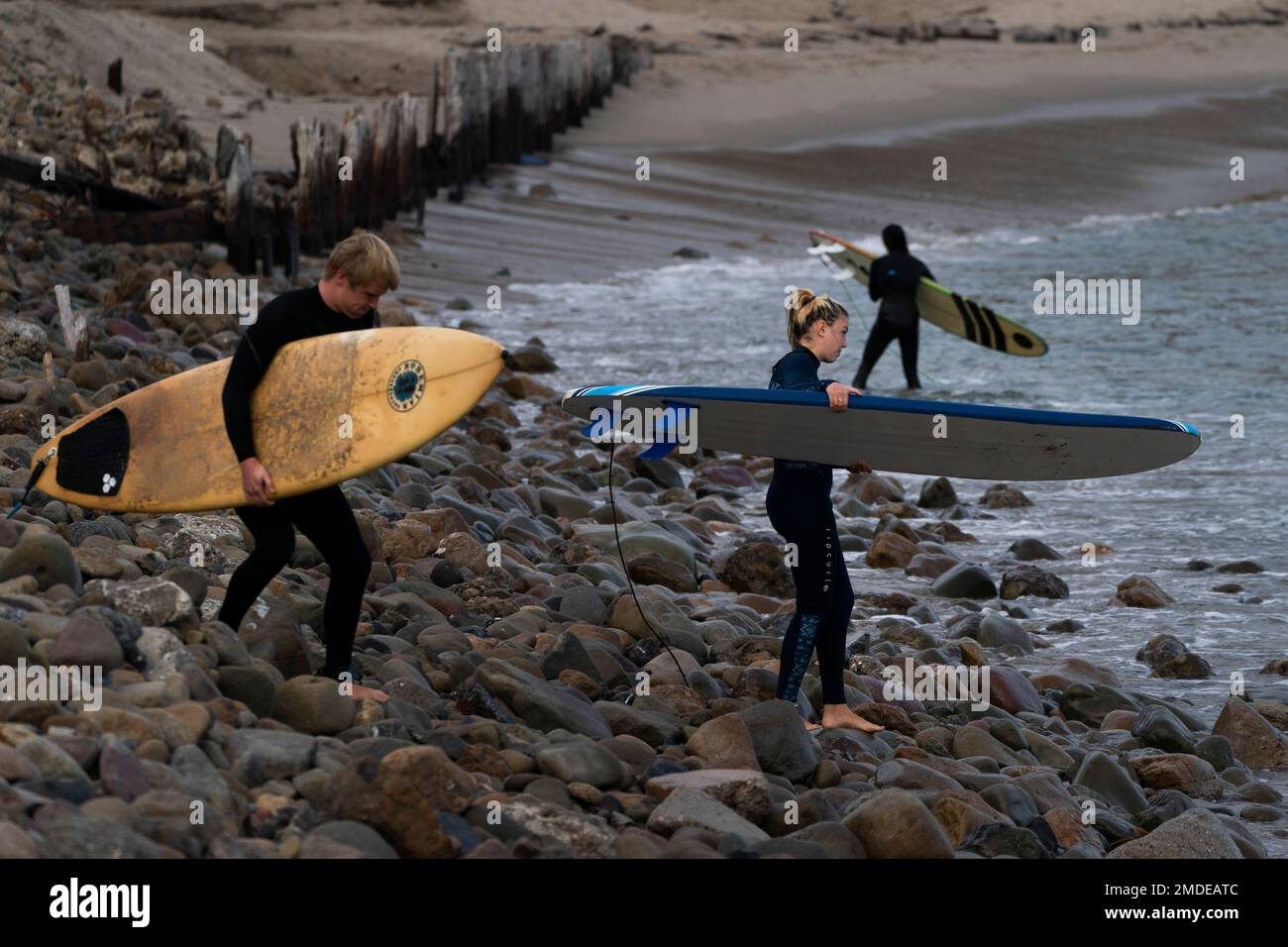Surfers walk into the ocean at Topanga Beach in Malibu, Calif., Tuesday ...