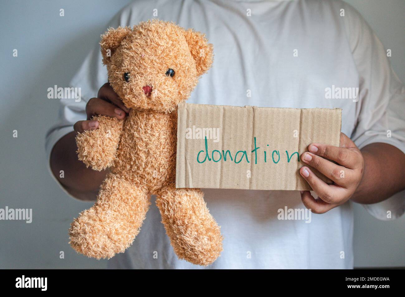 Male hand holding teddy bear for donation Stock Photo - Alamy