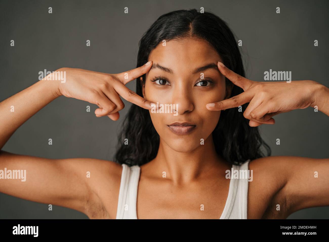 Multiethnic female making peace symbol with both hands Stock Photo - Alamy
