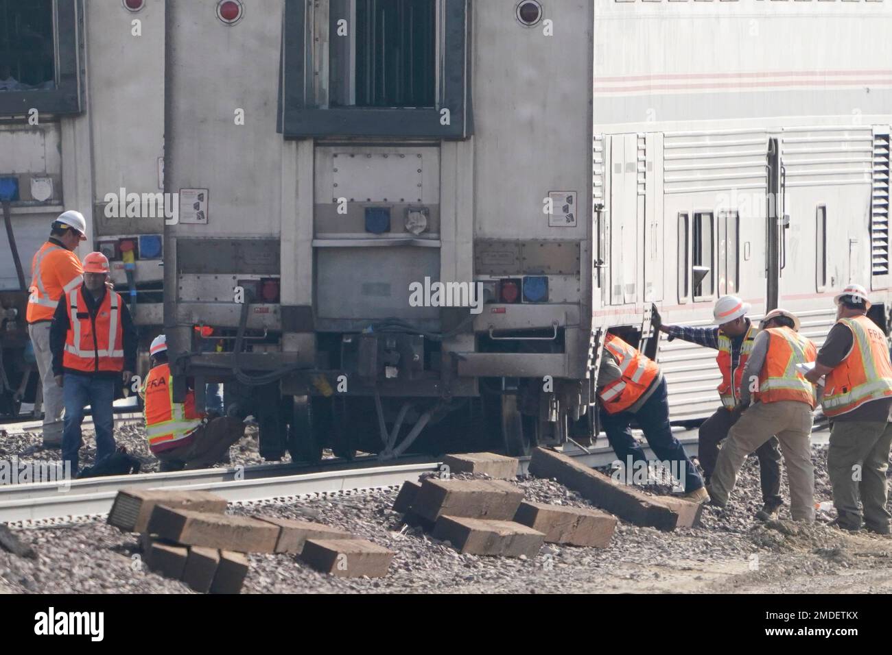 Workers examine a train car, Monday, Sept. 27, 2021, from an Amtrak ...