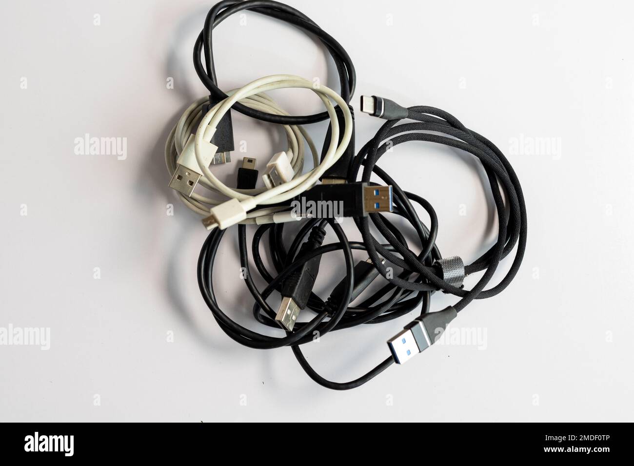 Tangled charging cables and wires for electrical devices Stock Photo ...