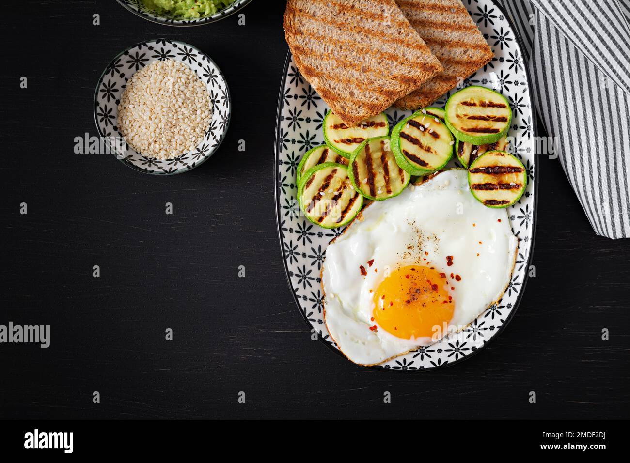 Breakfast. Toast with avocado guacamole, grilled zucchini and fried egg ...