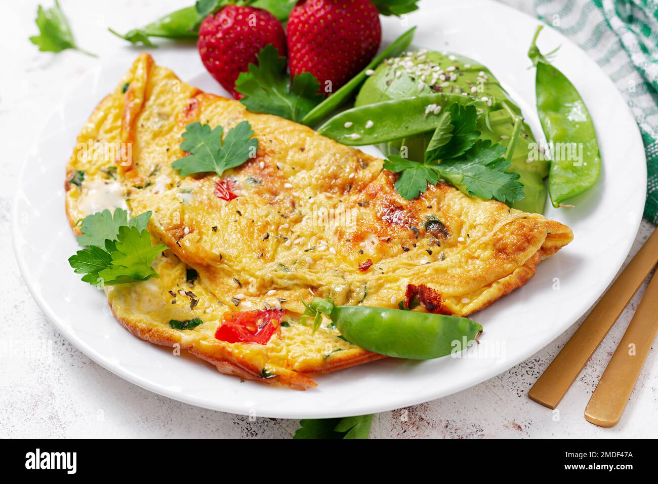 Omelette with tomatoes, feta cheese and avocado on white plate Stock ...