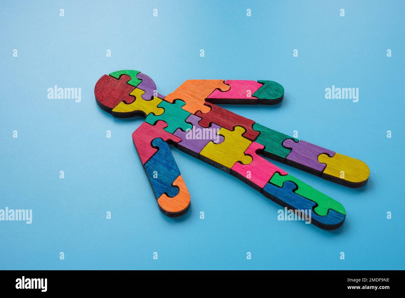 Figure of a man made of multi-colored puzzle pieces. Autism or ...