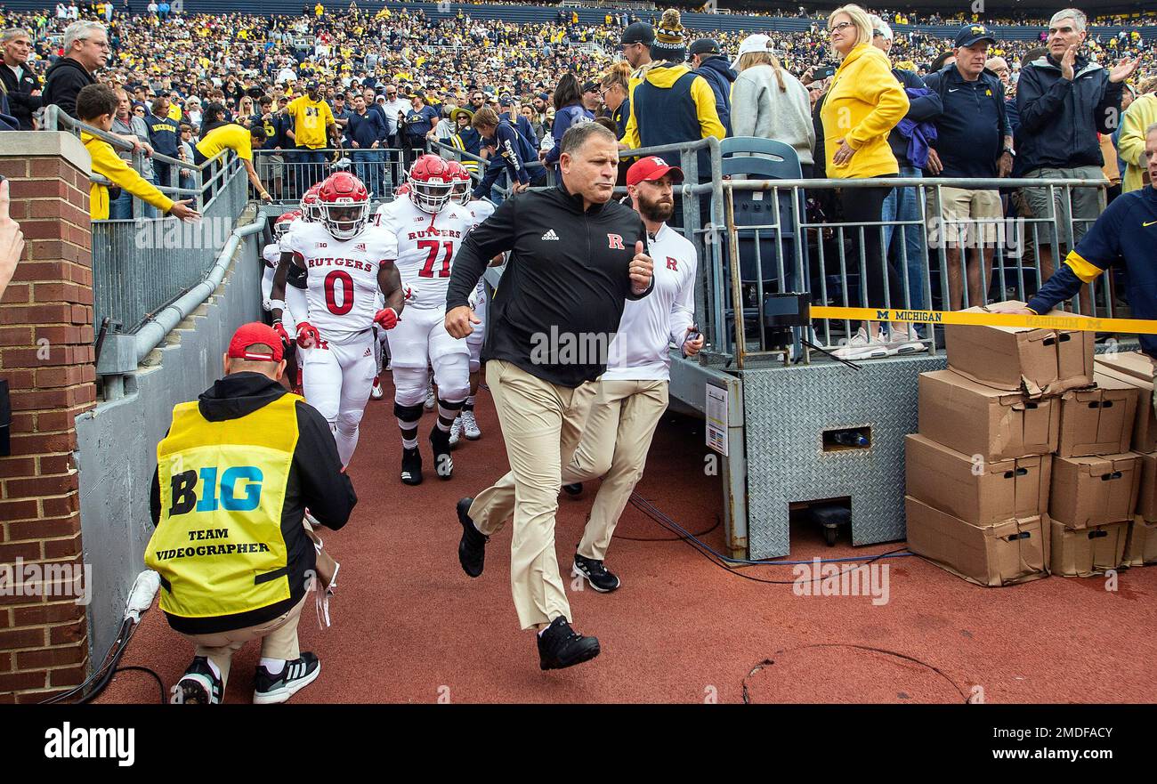 Rutgers head coach Greg Schiano leads his team out on the Michigan ...