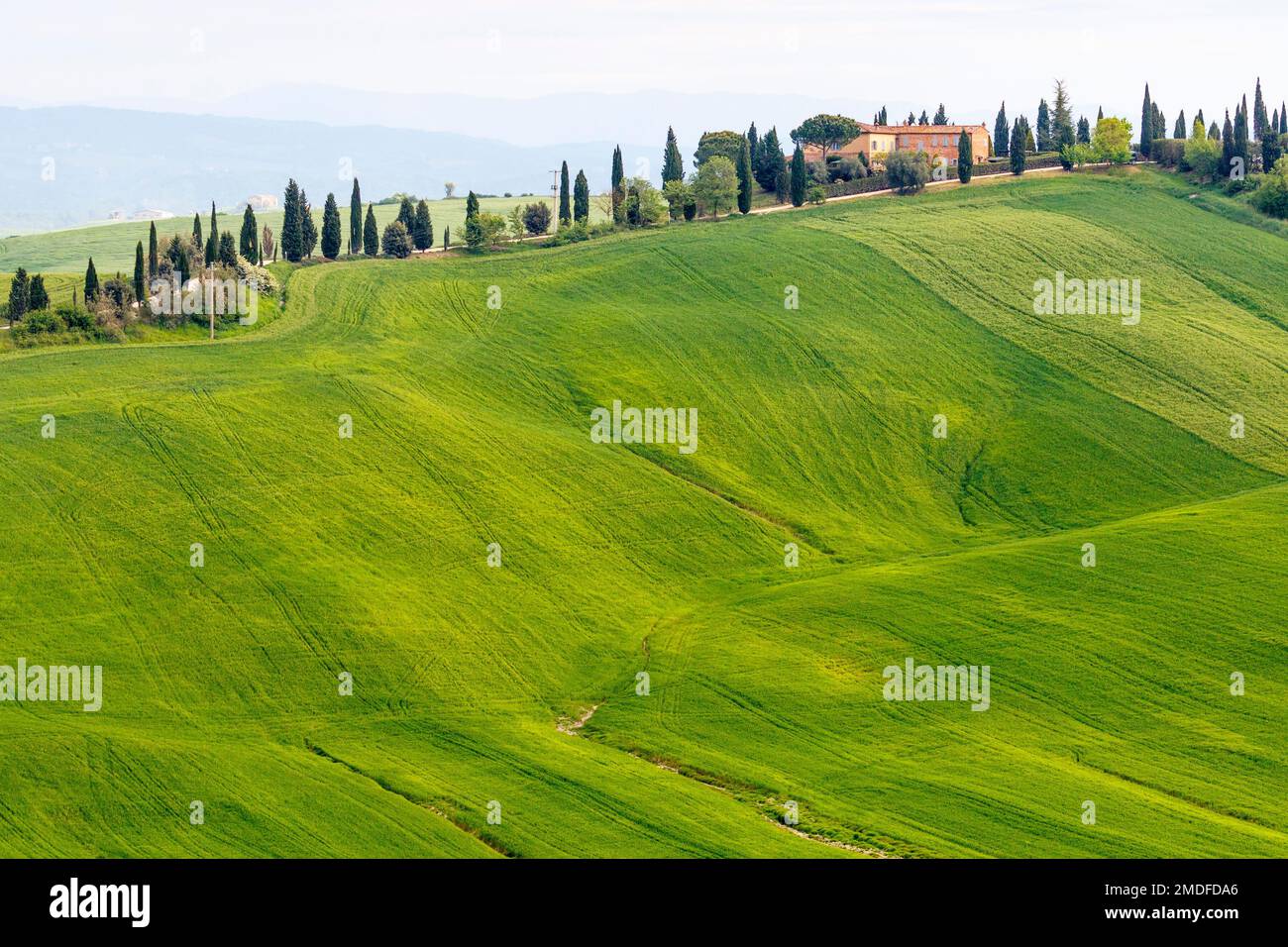 Green field with a farm on a hill Stock Photo - Alamy
