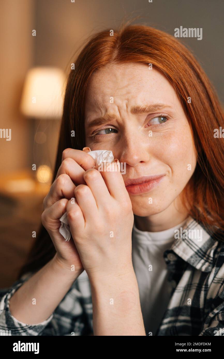 Close-up portrait of depressed woman crying and wiping tears with ...