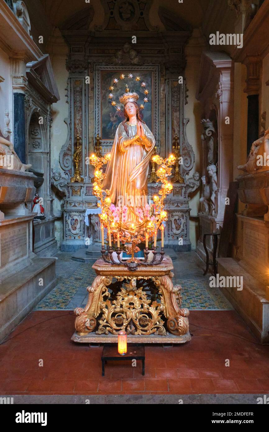 A statue, icon, relic of the Virgin Mary, hands praying, lit halo and ...