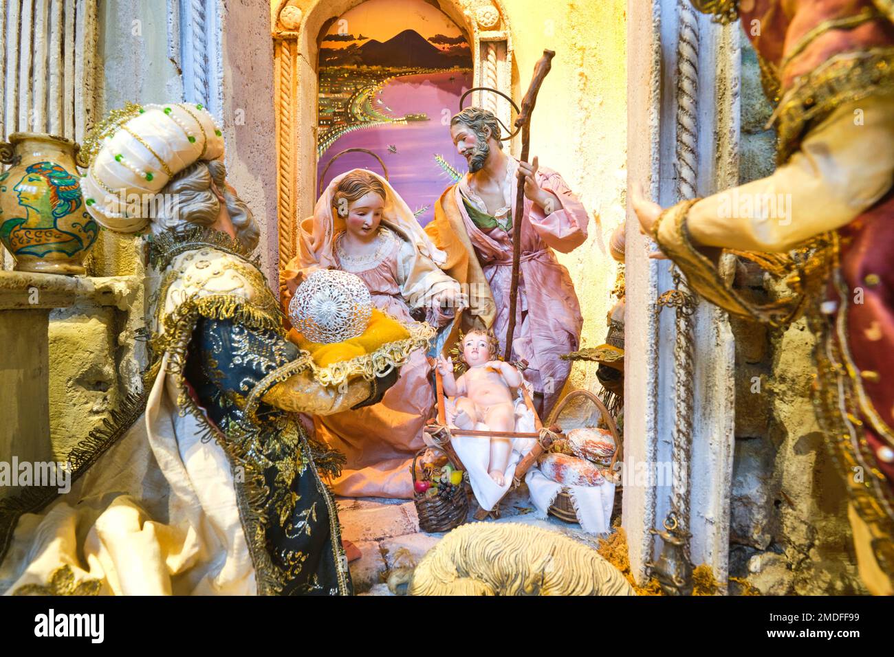 A diorama, full of figures showing the wise men giving gifts to baby ...