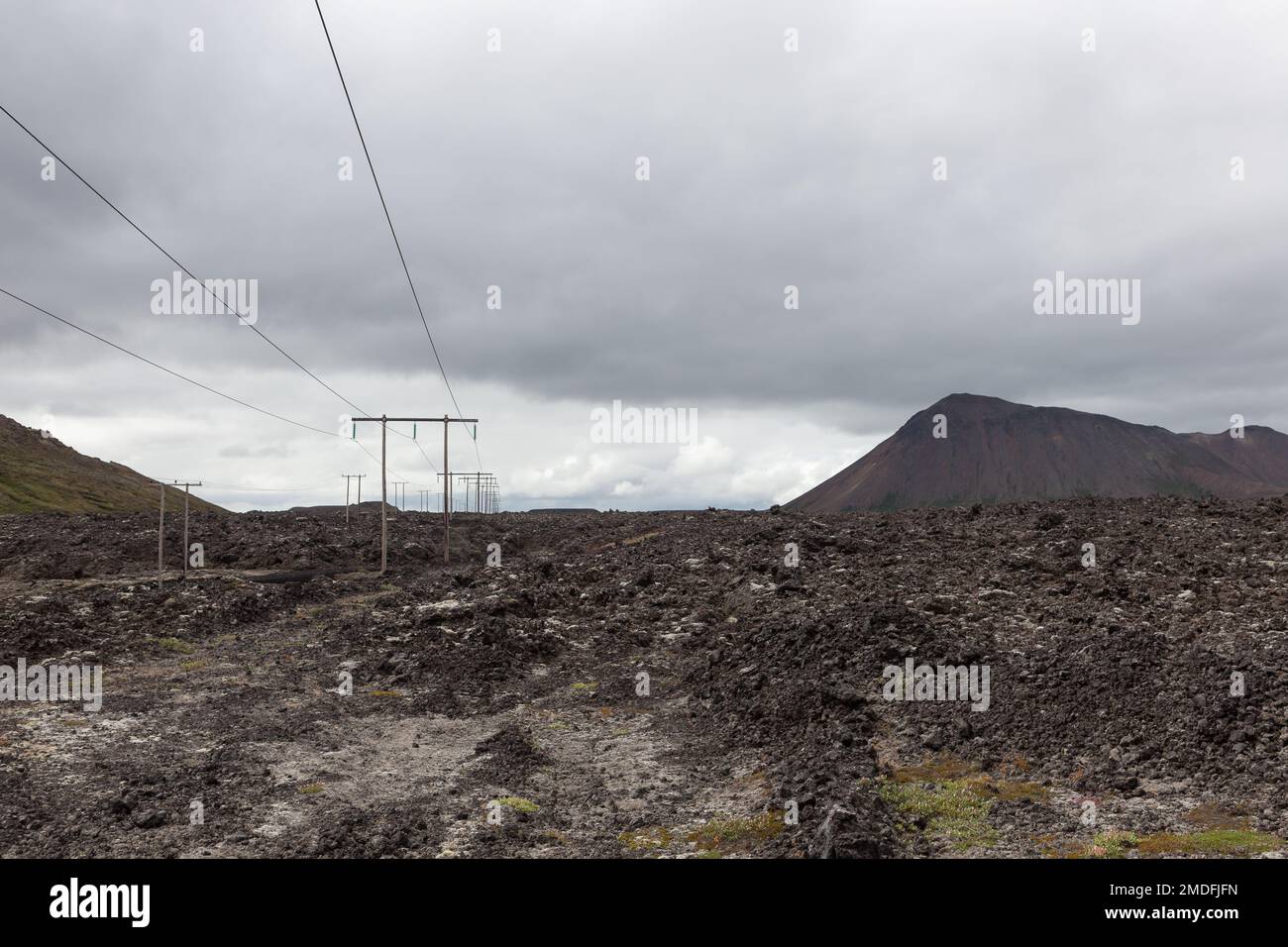 Electric power lines. Grey lava fields landscape. Volcanic apocalyptic ...