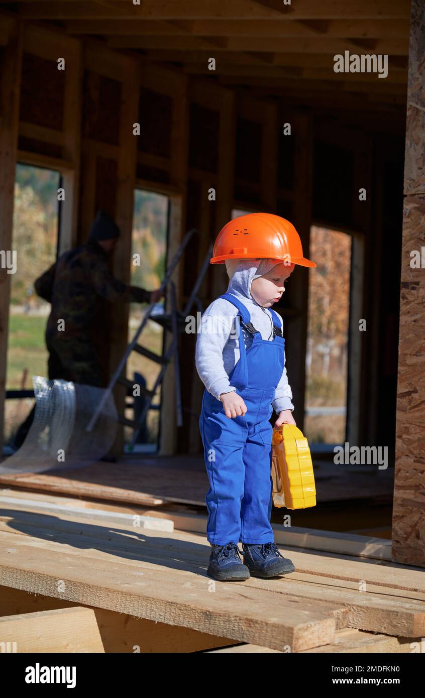 Boy toddler playing as builder on construction site. Child carpenter in ...