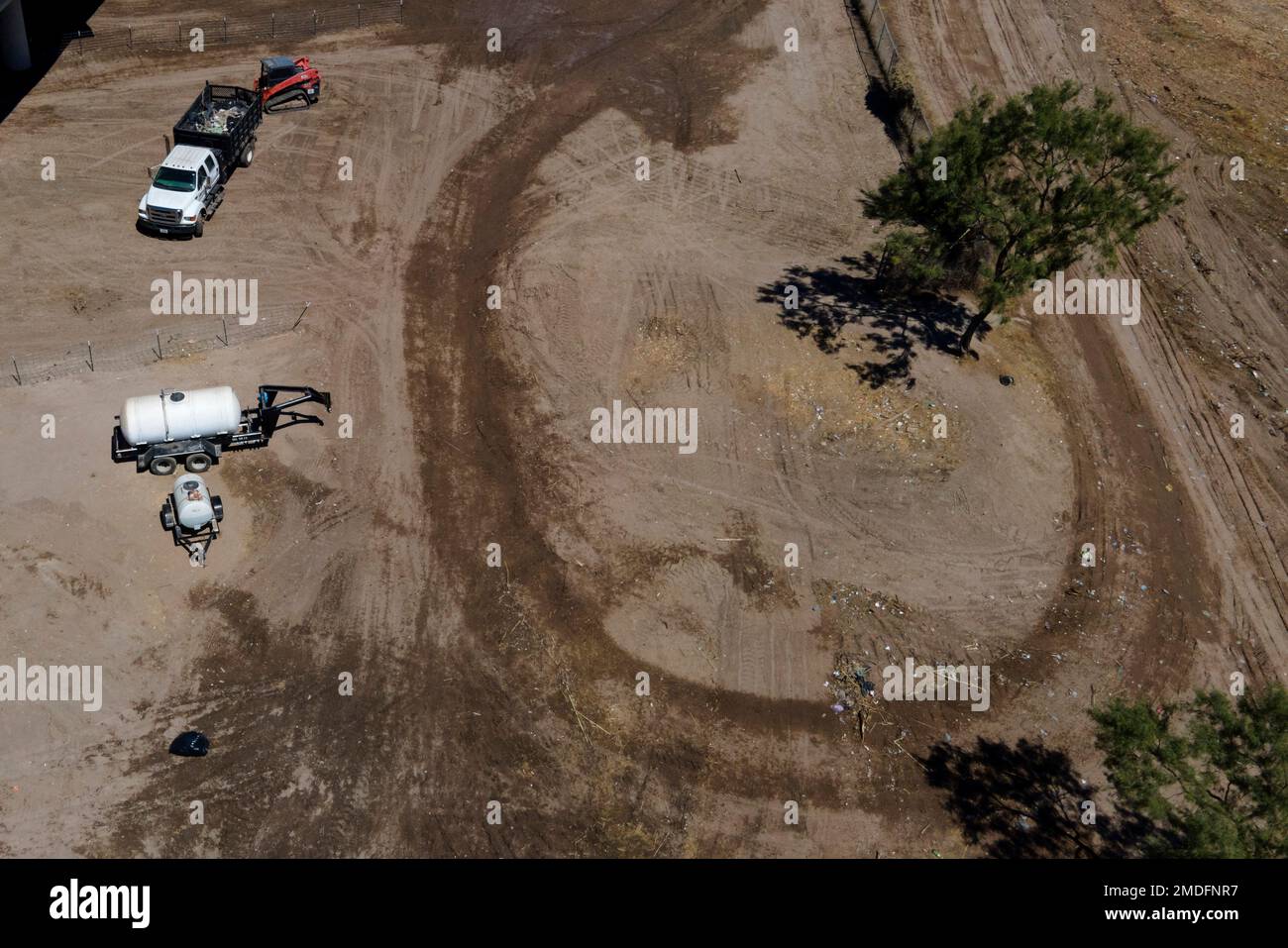 Crews clear an area used by migrants, many from Haiti, as an encampment ...