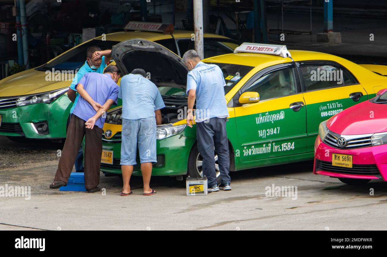 SAMUT PRAKAN, THAILAND, OCT 12 2022, Taxi drivers at the taxi rank inspect the taxi car Stock ...
