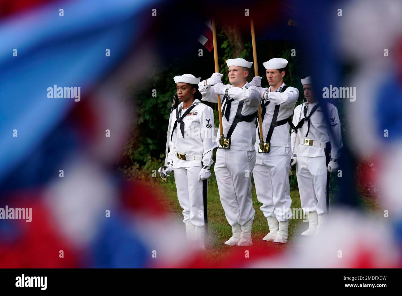 U.S. Navy sailors from the USS Constitution display flags as they form ...