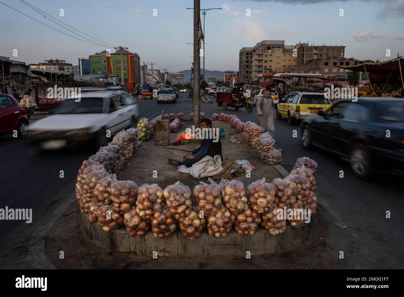 An Afghan man sells fruit in the middle of a street in Kabul ...