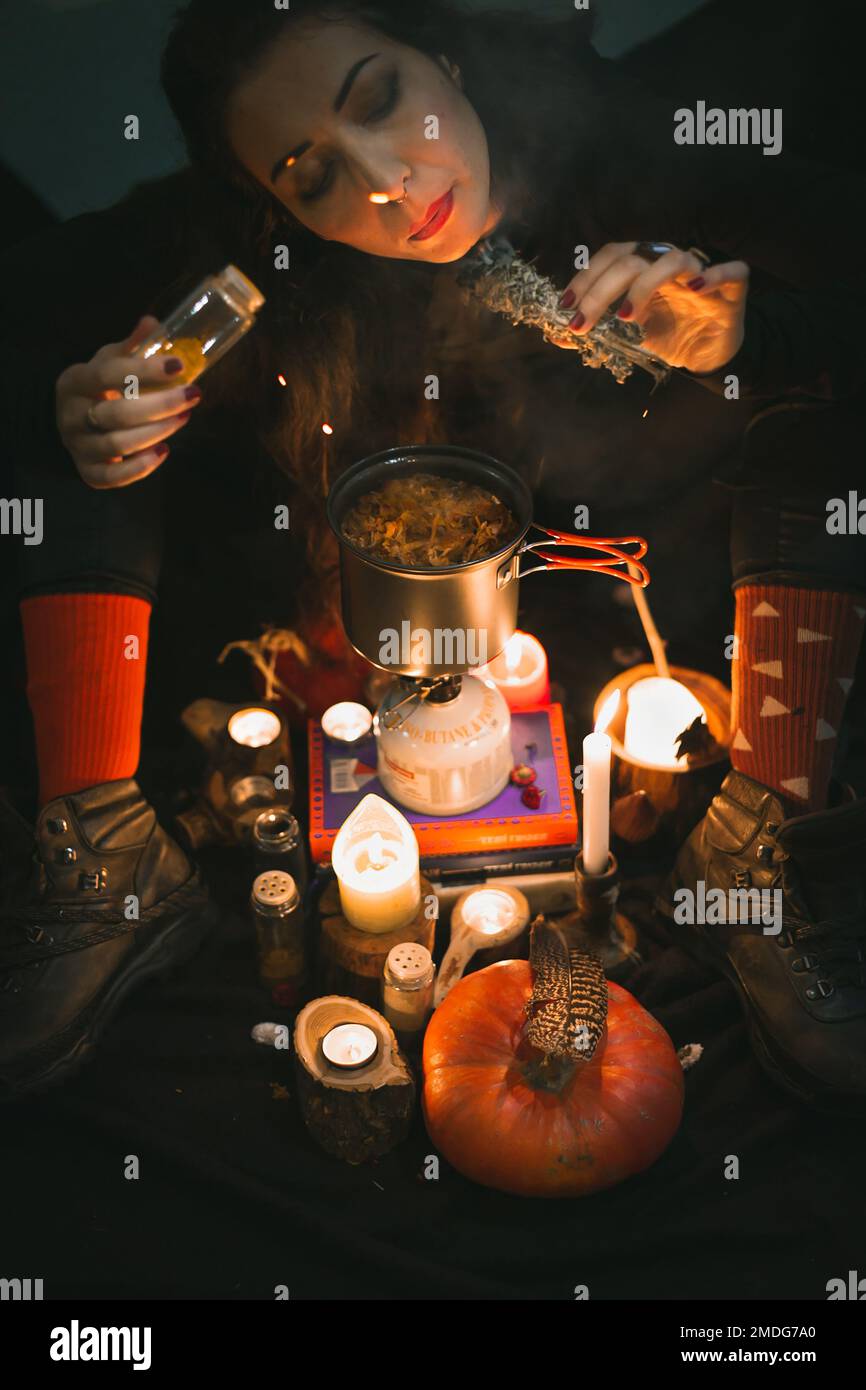 Close up woman witch brewing herbs and adding spices portrait picture ...