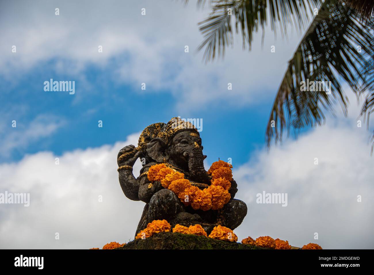 A Hindu Ganesha statue with an orange flower necklace Stock Photo - Alamy