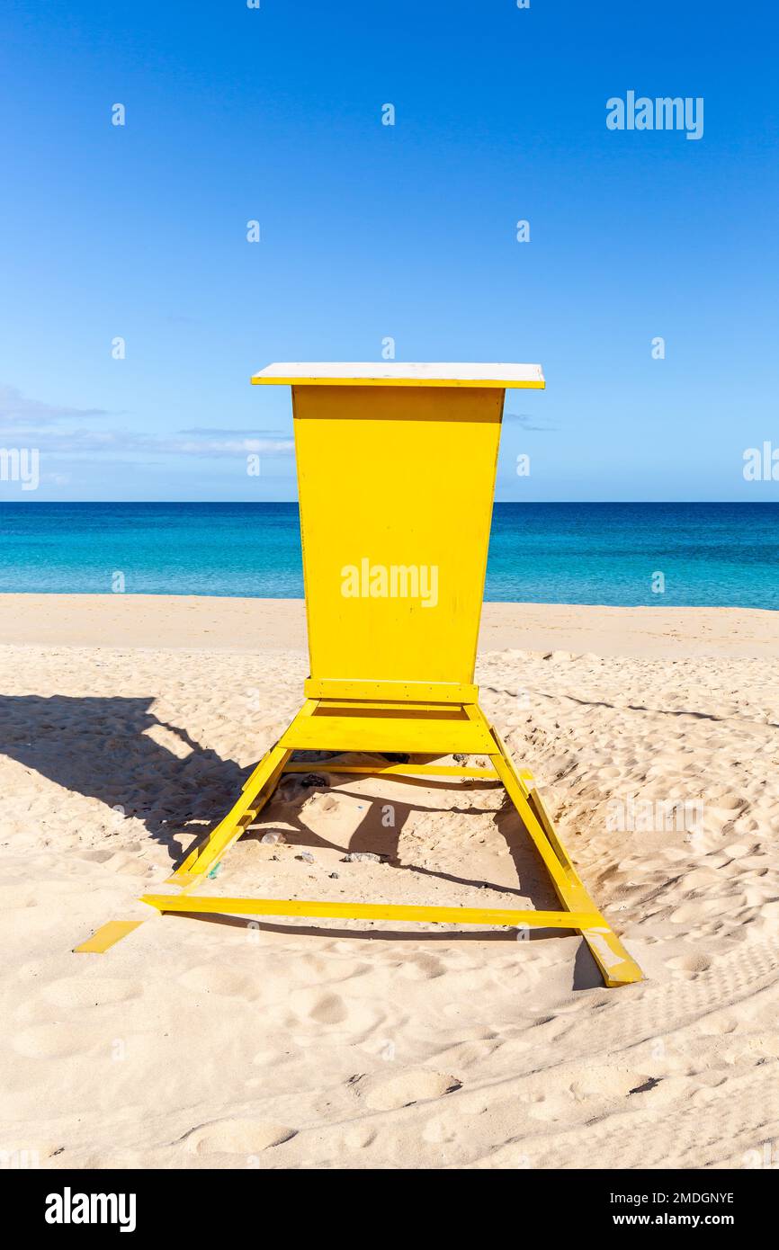 bright yellow lifeguard cabin, standing out against an intense blue ...