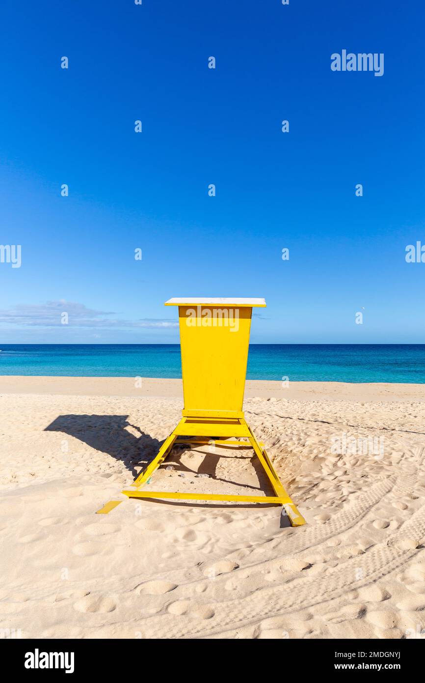bright yellow lifeguard cabin, standing out against an intense blue ...