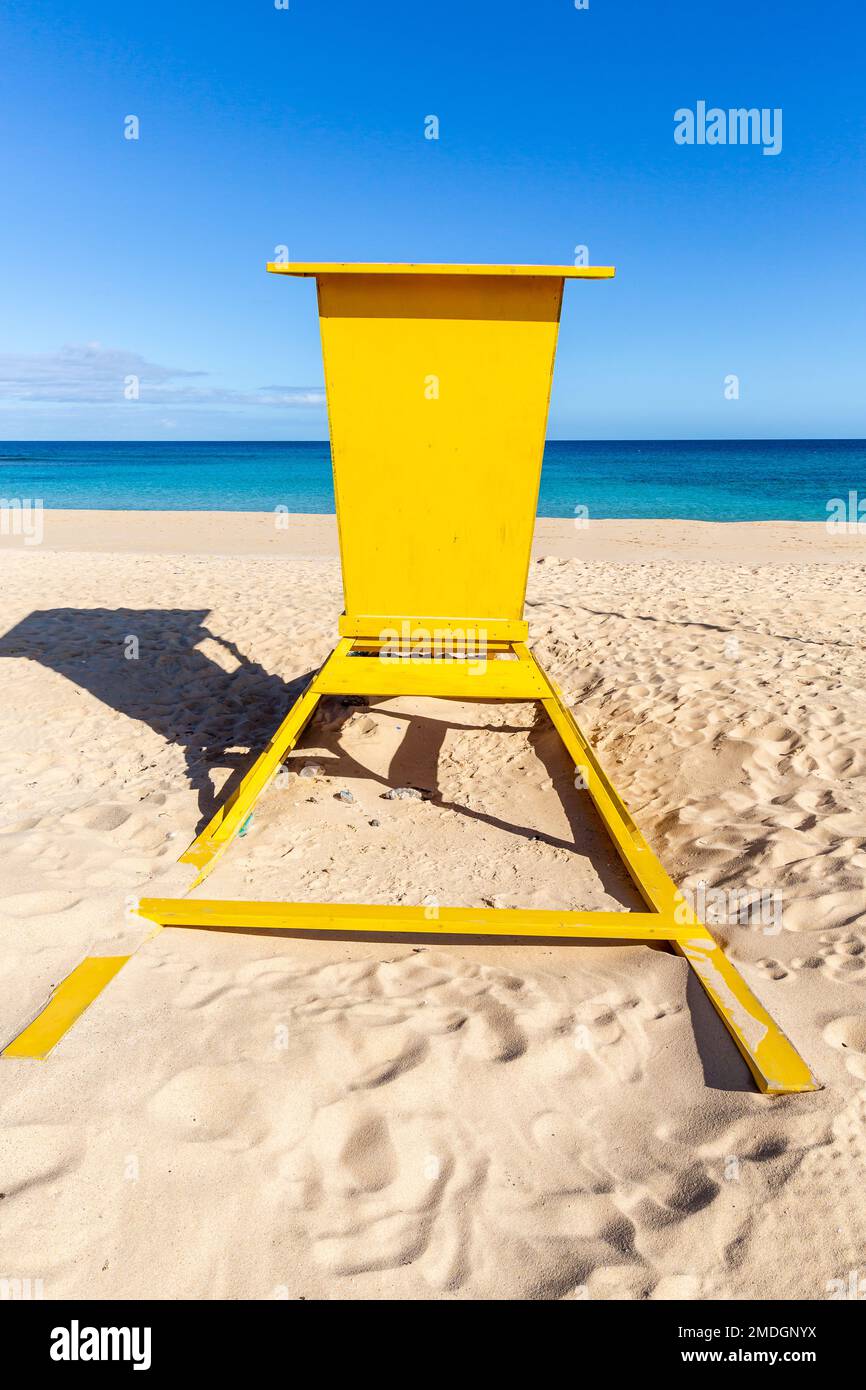 bright yellow lifeguard cabin, standing out against an intense blue ...
