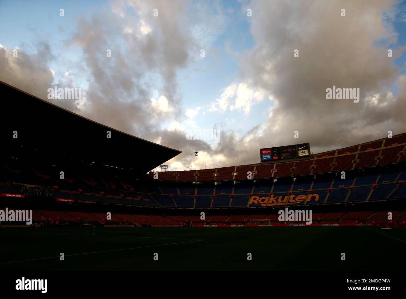 Clouds are illuminated by the setting sun above the Camp Nou stadium ...