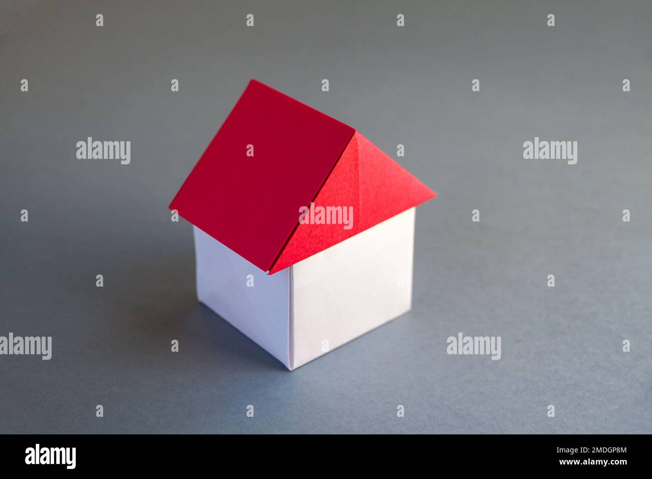 White and red paper house origami isolated on a grey background Stock ...